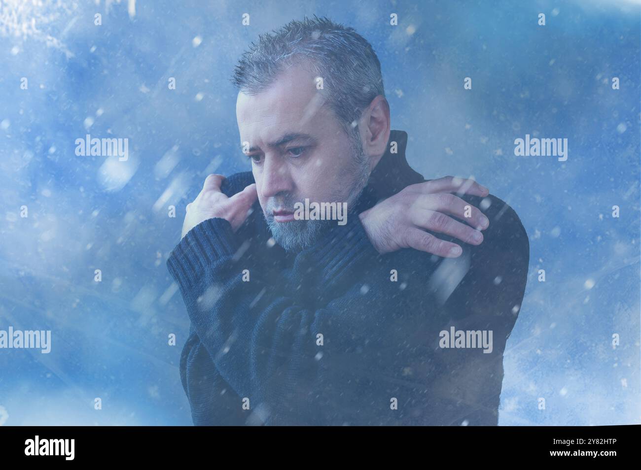 Frozen man shivering from cold weather on a blue snowy background. Man ...