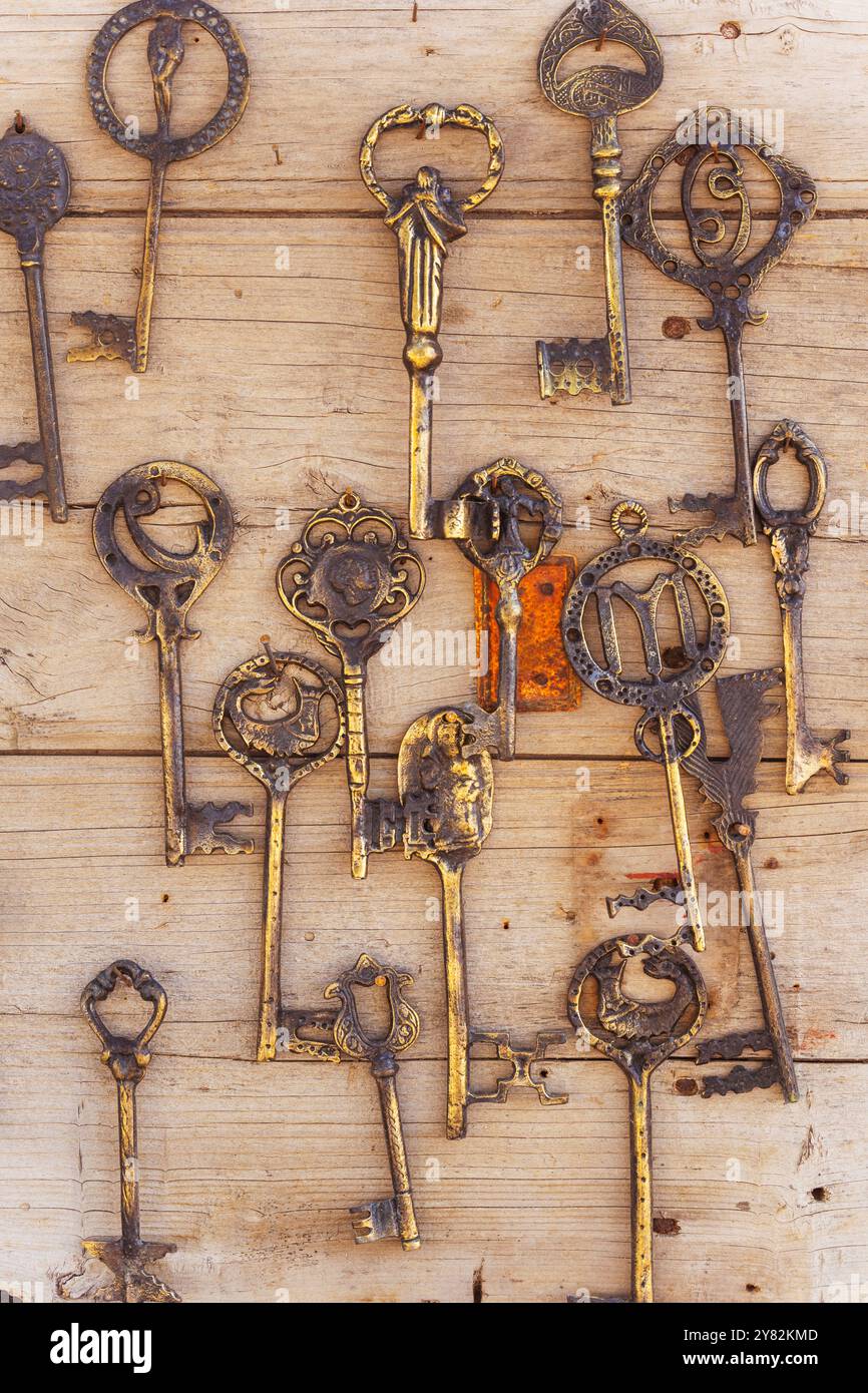 A collection of old and rusted keys are hanging on a wooden wall Stock ...