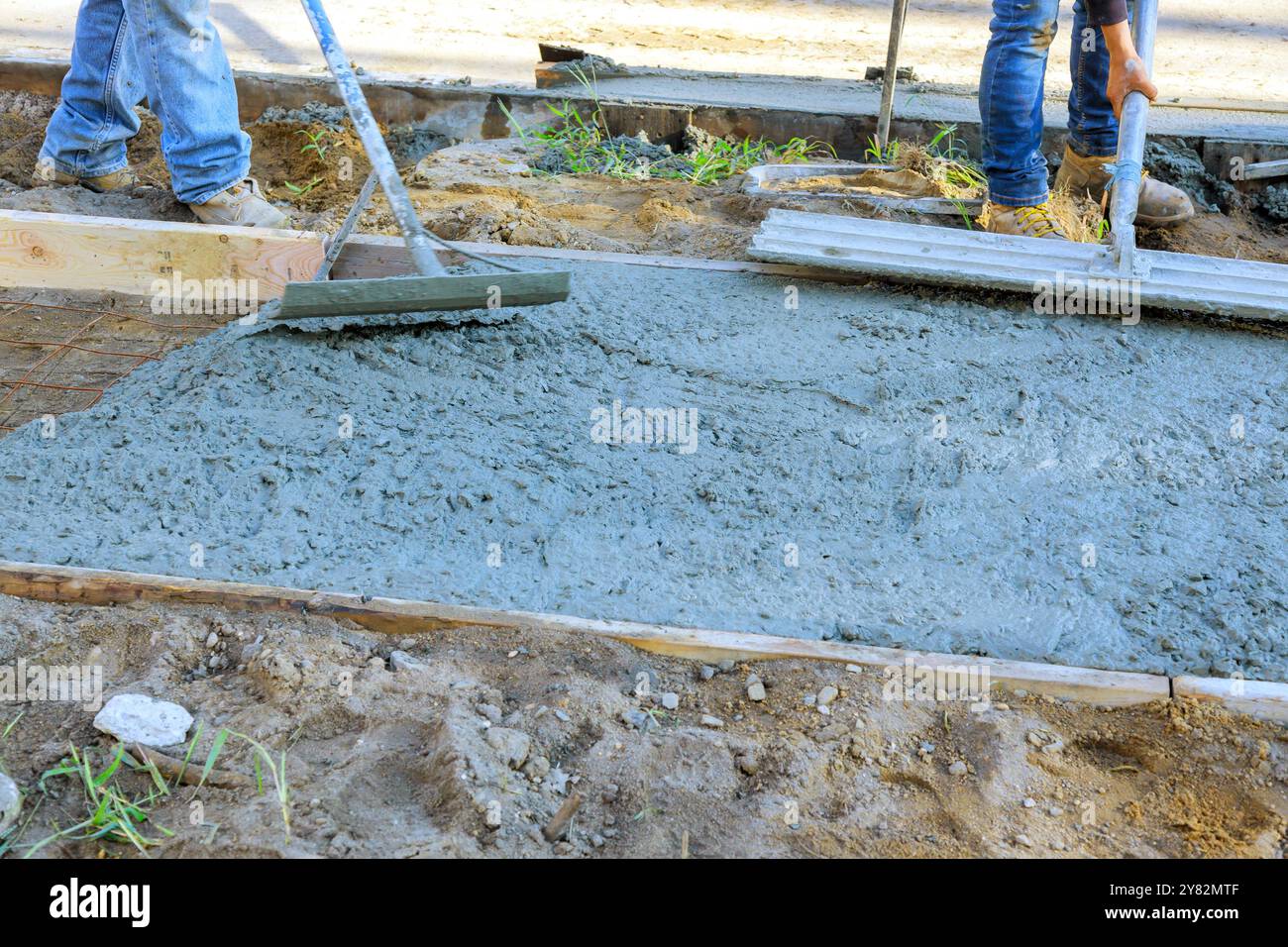 Worker using trowel leveling concrete during freshly cement pouring of ...