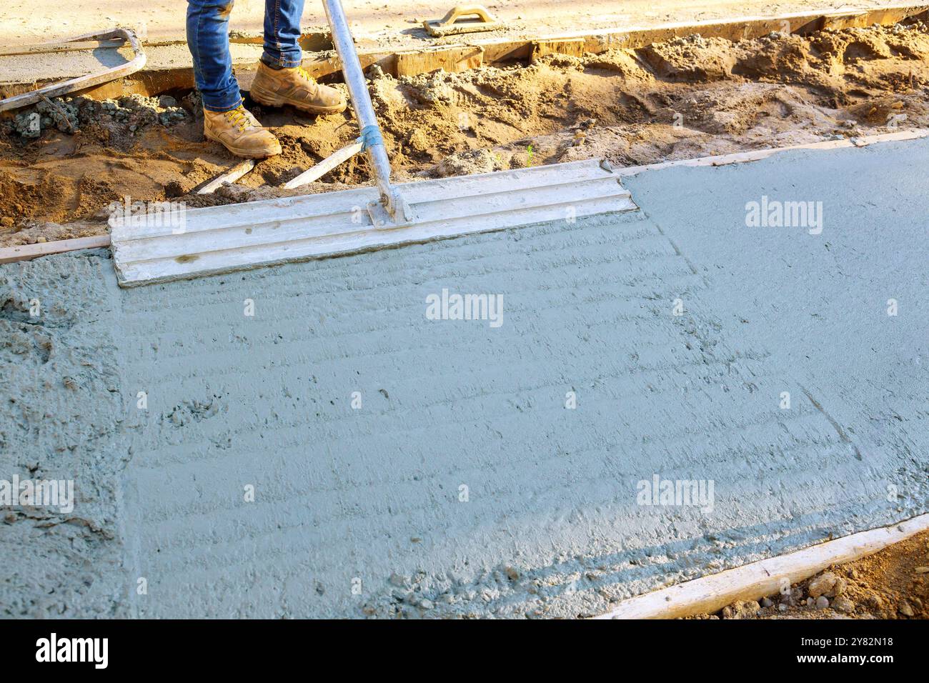 Leveling concrete using trowel during pouring of freshly concreted ...