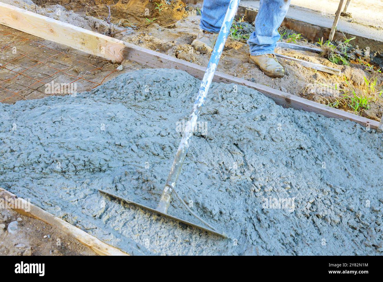 Leveling concrete with trowel during pouring of freshly cement concrete ...