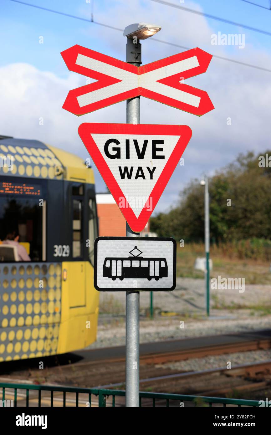 Give way warning sign and black and white tram sign at tram crossing ...