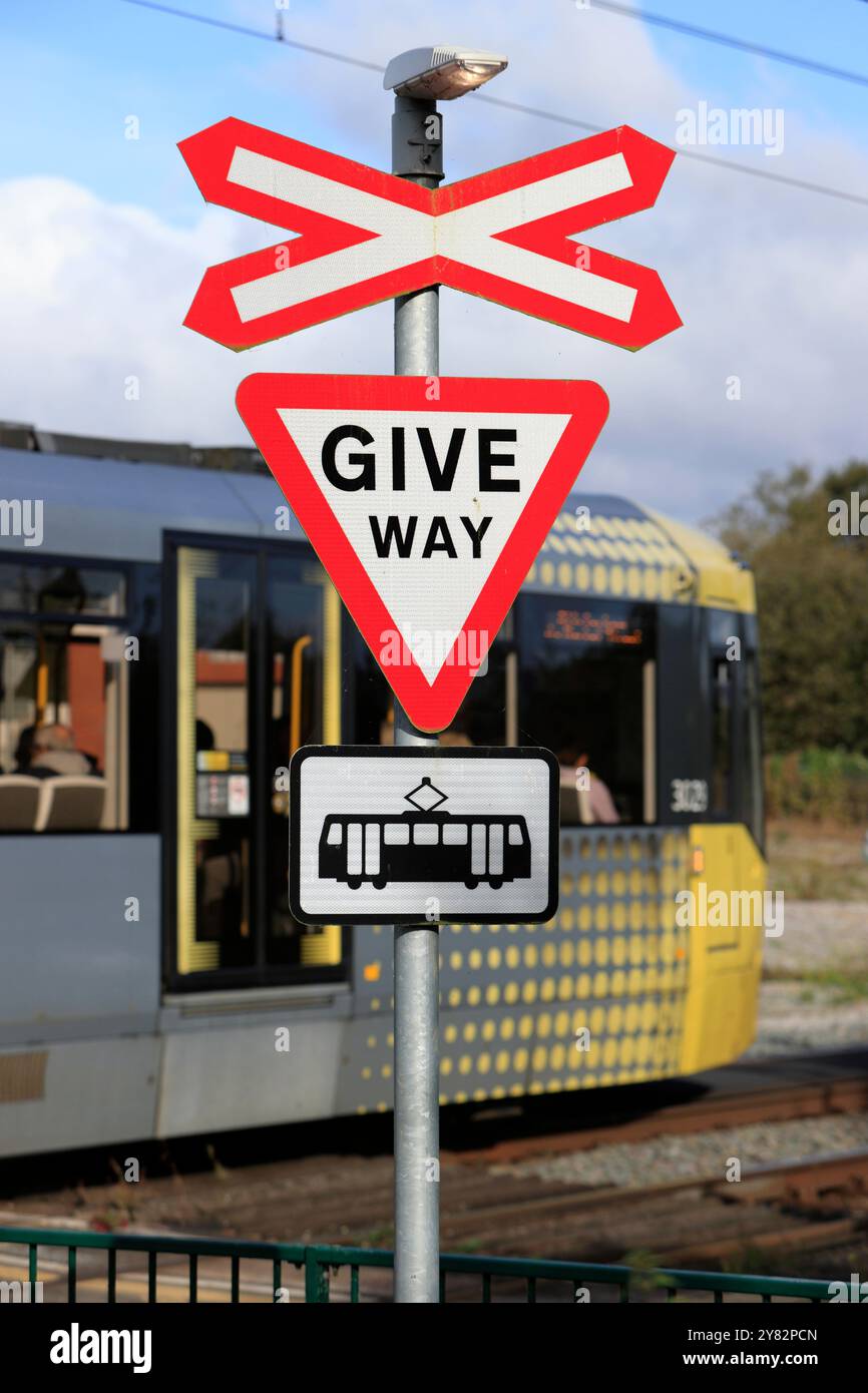 Give way warning sign and black and white tram sign at tram crossing ...