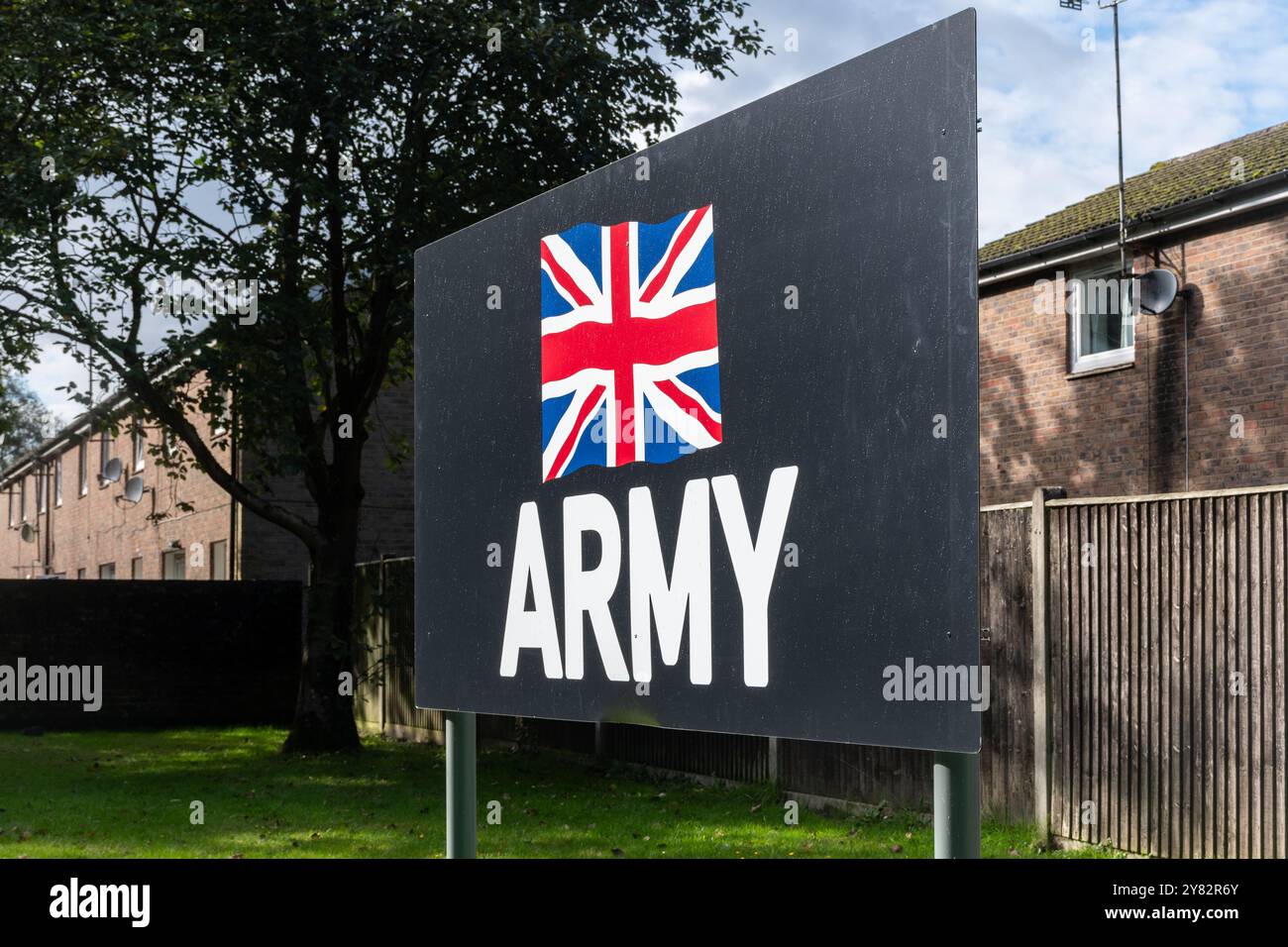 Army sign or notice with a Union Jack flag, beside British army housing ...