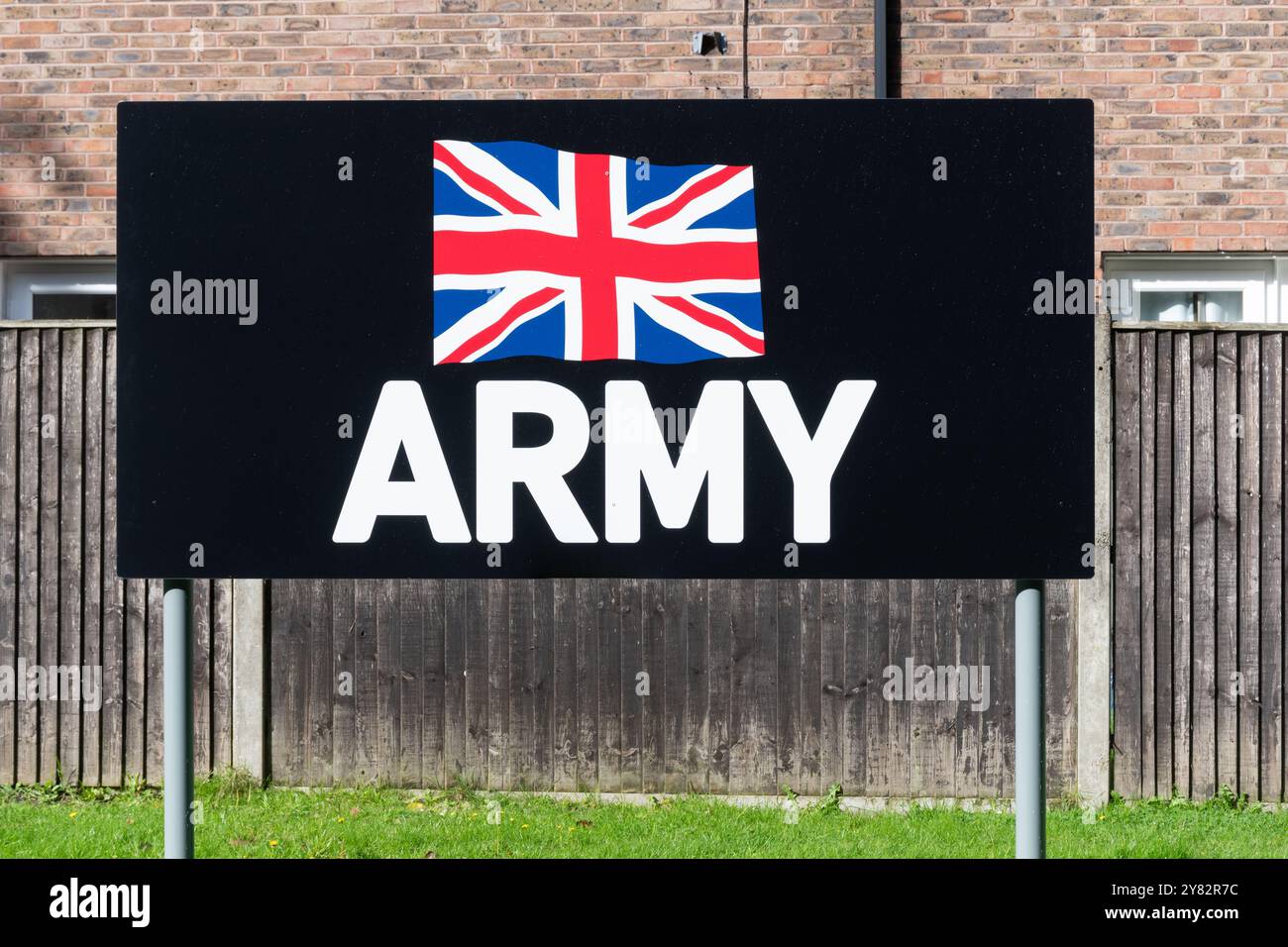 Army sign or notice with a Union Jack flag, beside British army housing ...