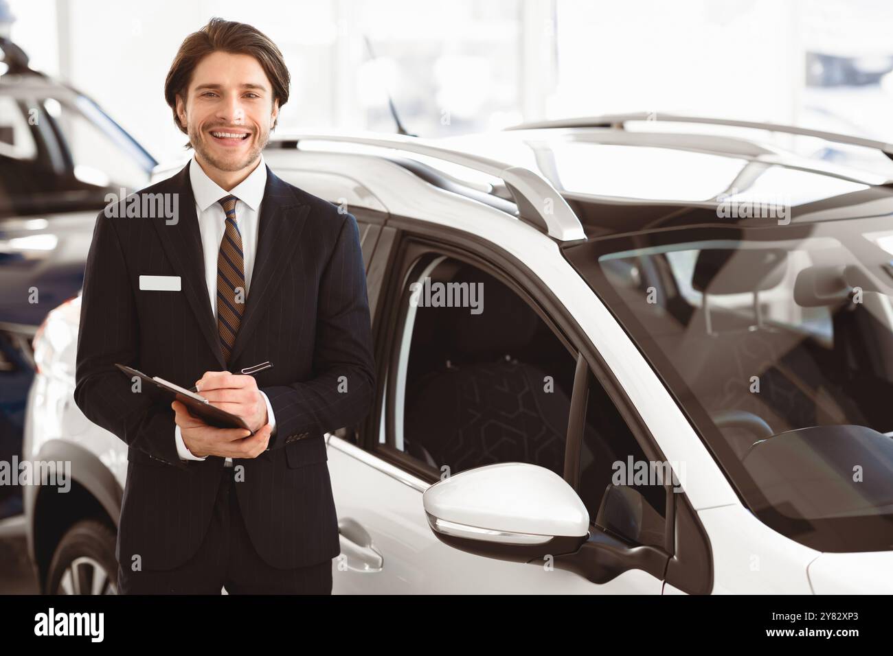 Salesman Selling Car Posing In Dealership Center Stock Photo - Alamy