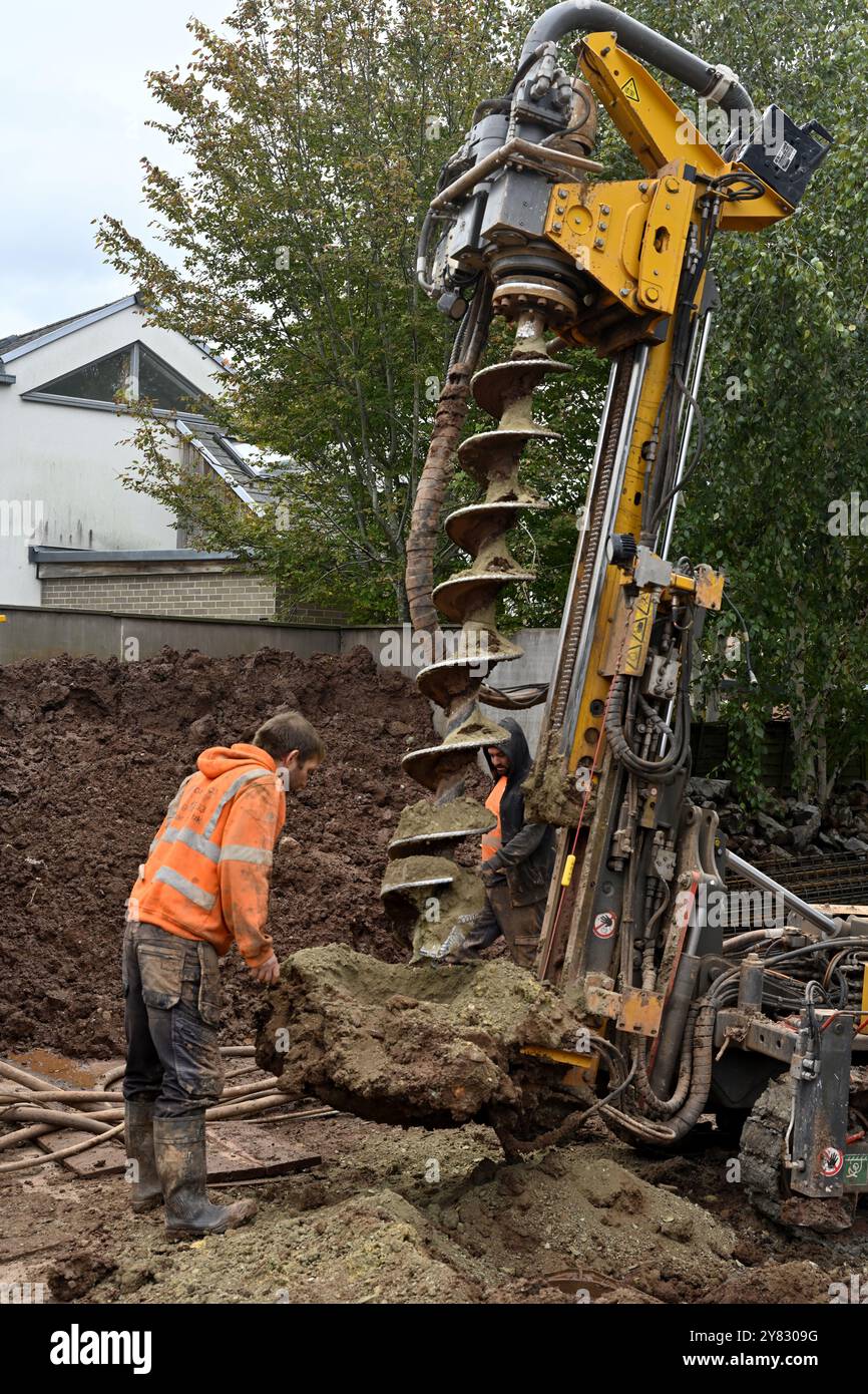 Repositioning auger pile drilling machine on domestic construction site ...