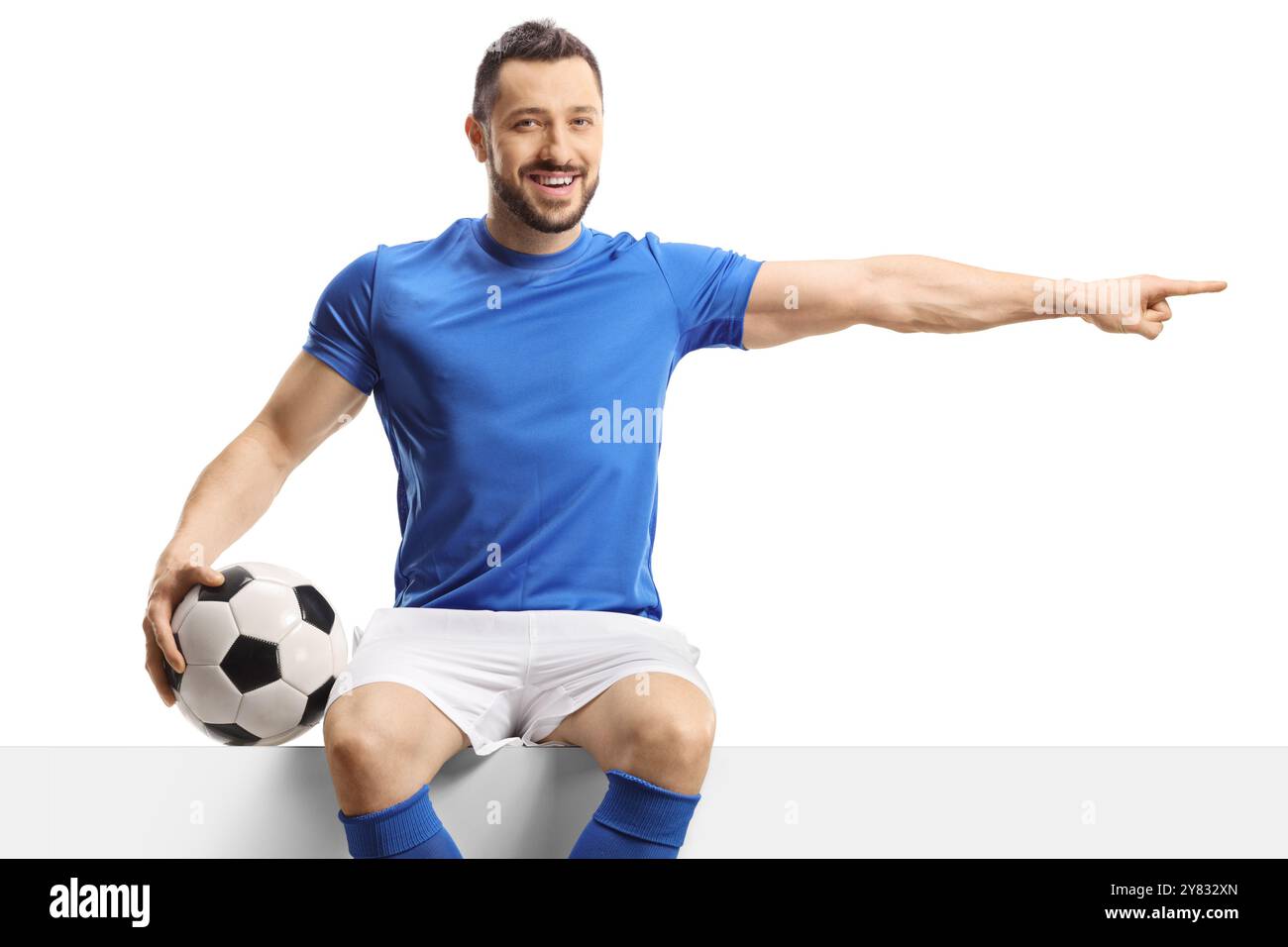 Football player in a blue jersey with a ball sitting on a blank panel ...