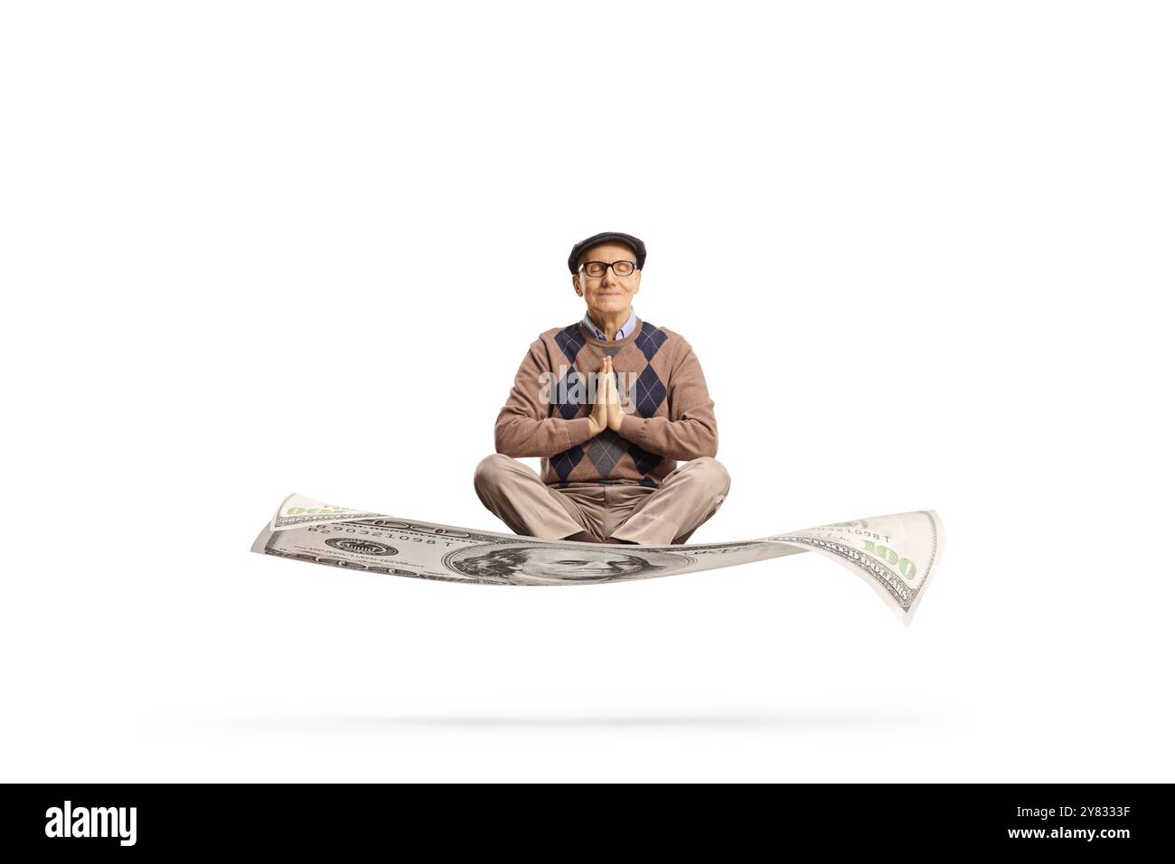 Elderly man sitting on a money banknote in a meditation pose isolated ...