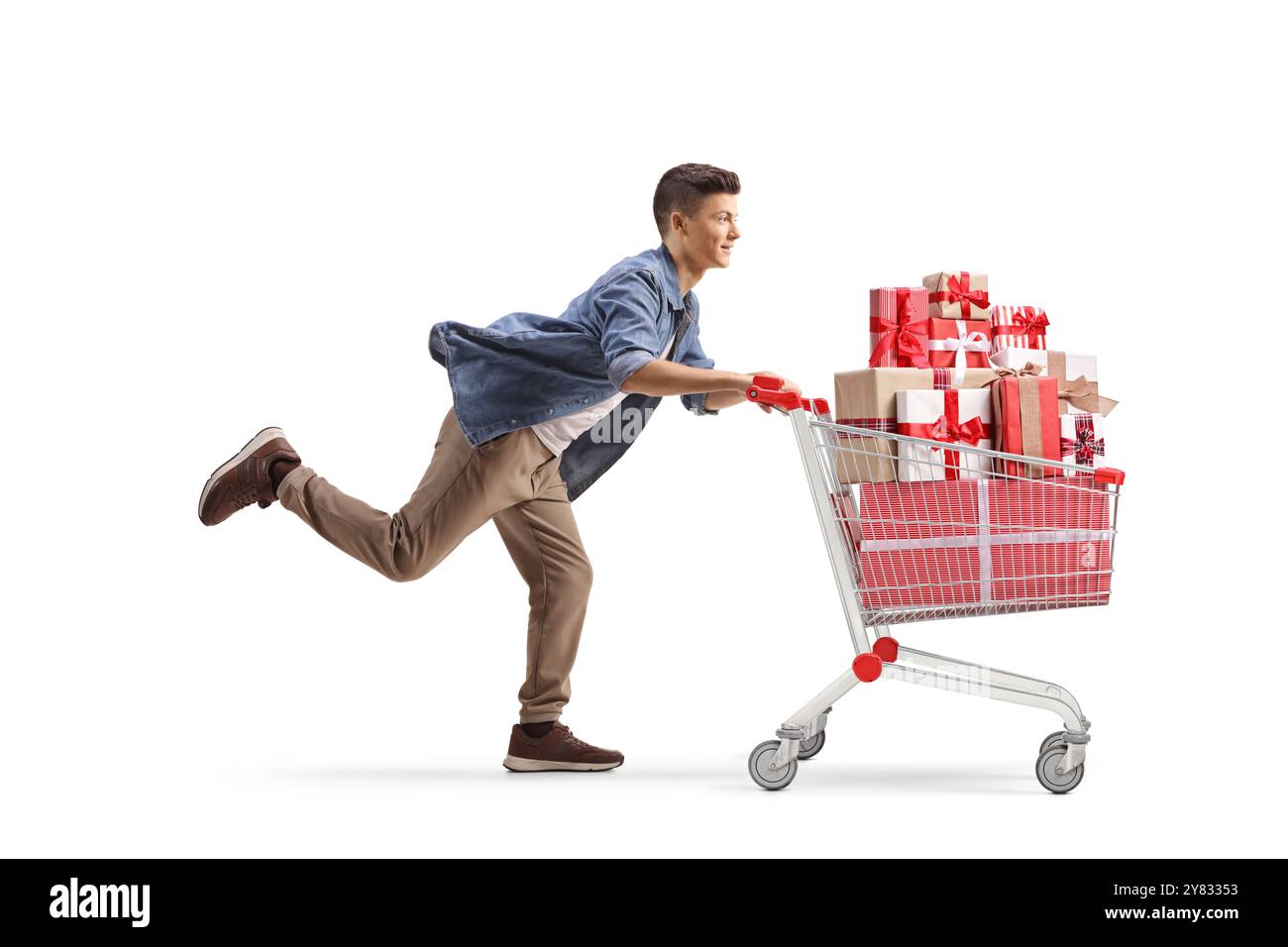 Young man running with a pile of presents in a shopping cart isolated ...