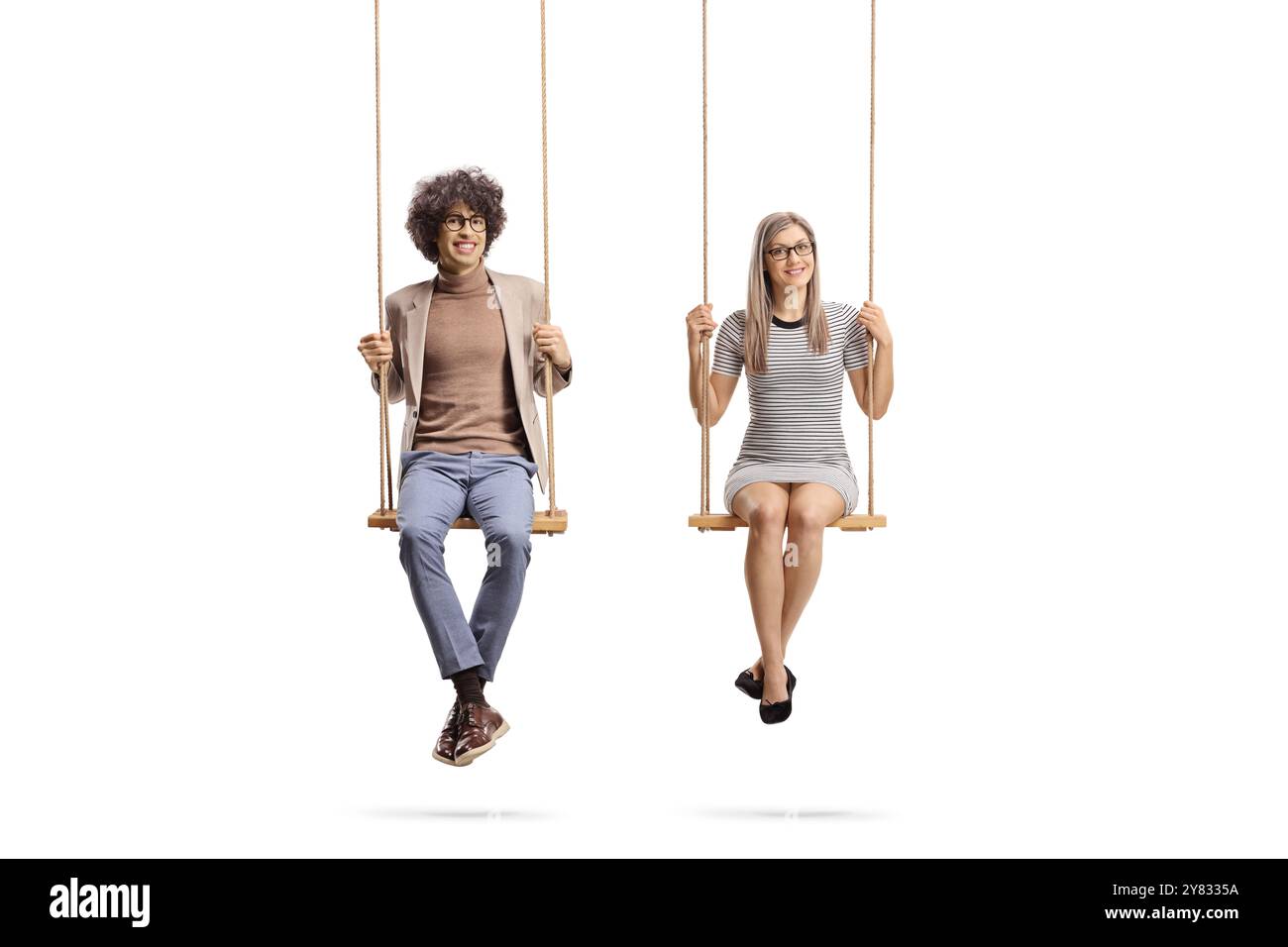 Young man and woman sitting on swings and smiling isolated on white ...