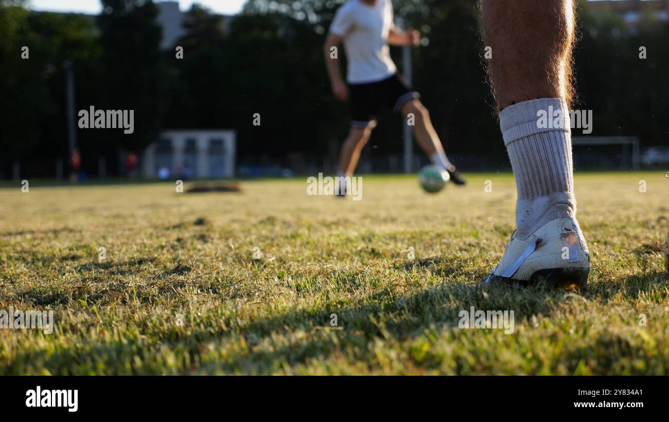 Male feet of professional footballers passing soccer ball on stadium at ...