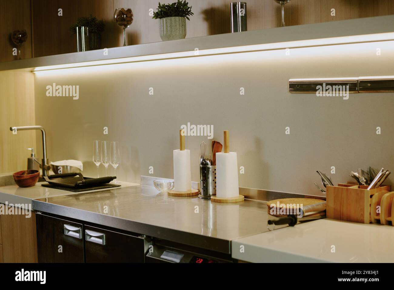 Wooden kitchen counter with kitchenware and dishes on white granite top ...