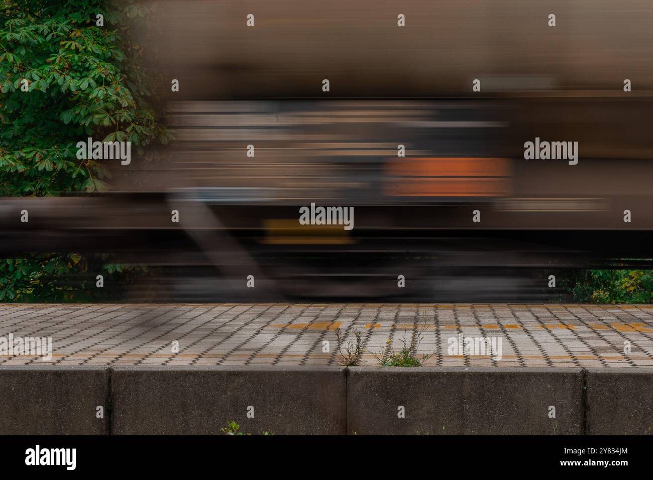 Freight train passing passenger track in motion, visible motion blur of ...