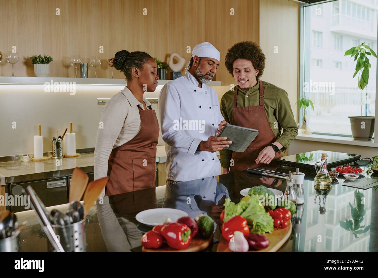 Professional chef holding touchpad with new menu and discussing it with ...
