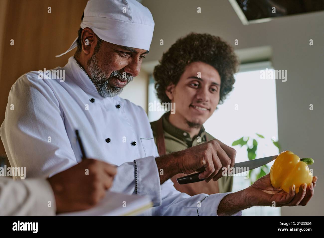 Low angle shot of Indian professional chef showing peeling skills to ...