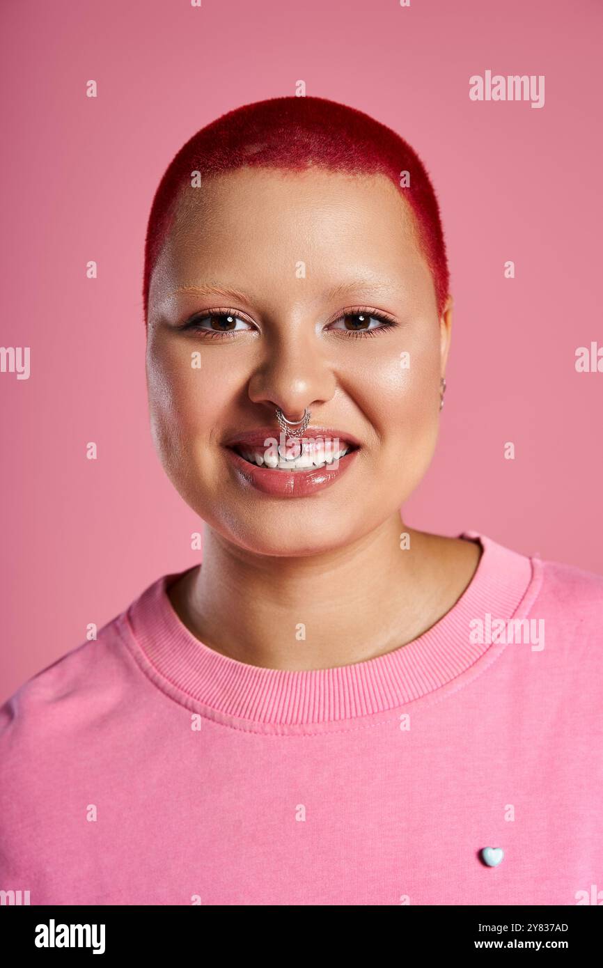 Showcasing vibrant style, a young woman with short pink hair and a nose ...
