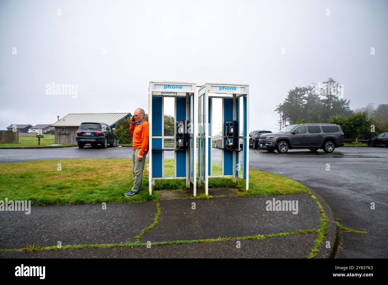 A single senior male uses a cell phone and a landline at the same time ...