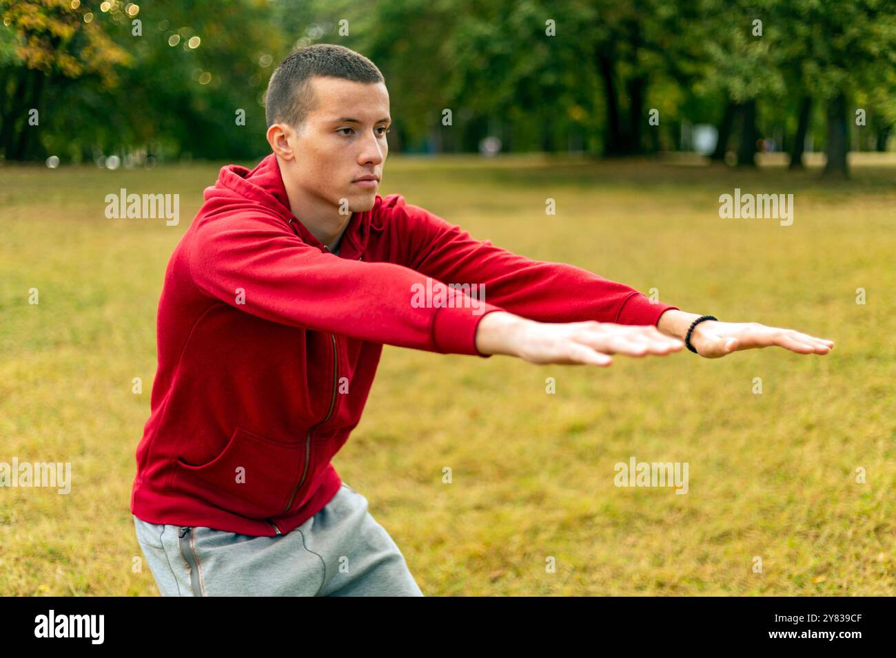 Sport man stretching at the park autumn, doing exercises.Handsome man ...