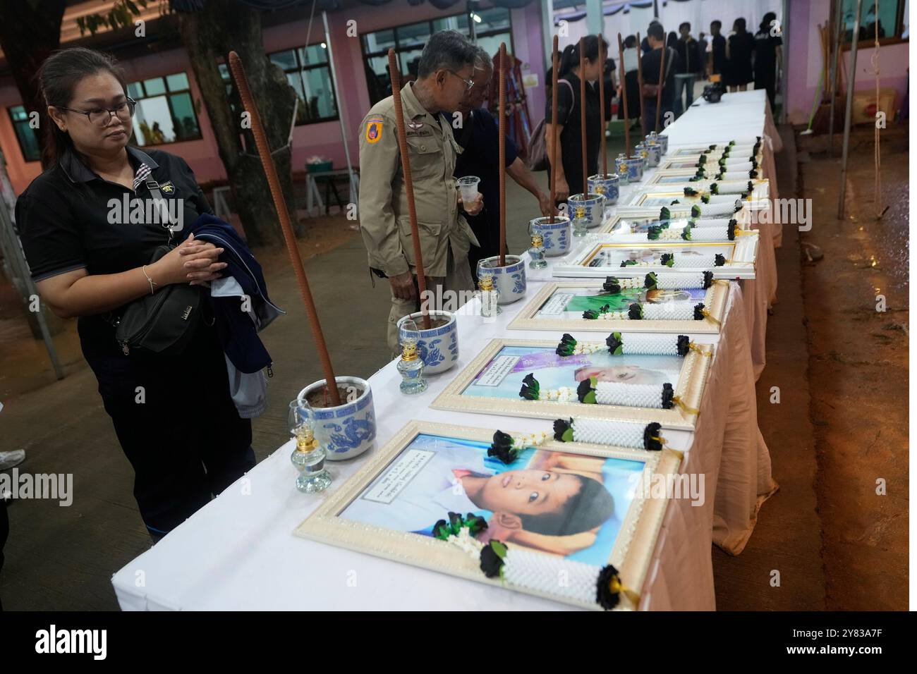 Relatives of the bus fire victims view their portraits at the Wat Khao ...