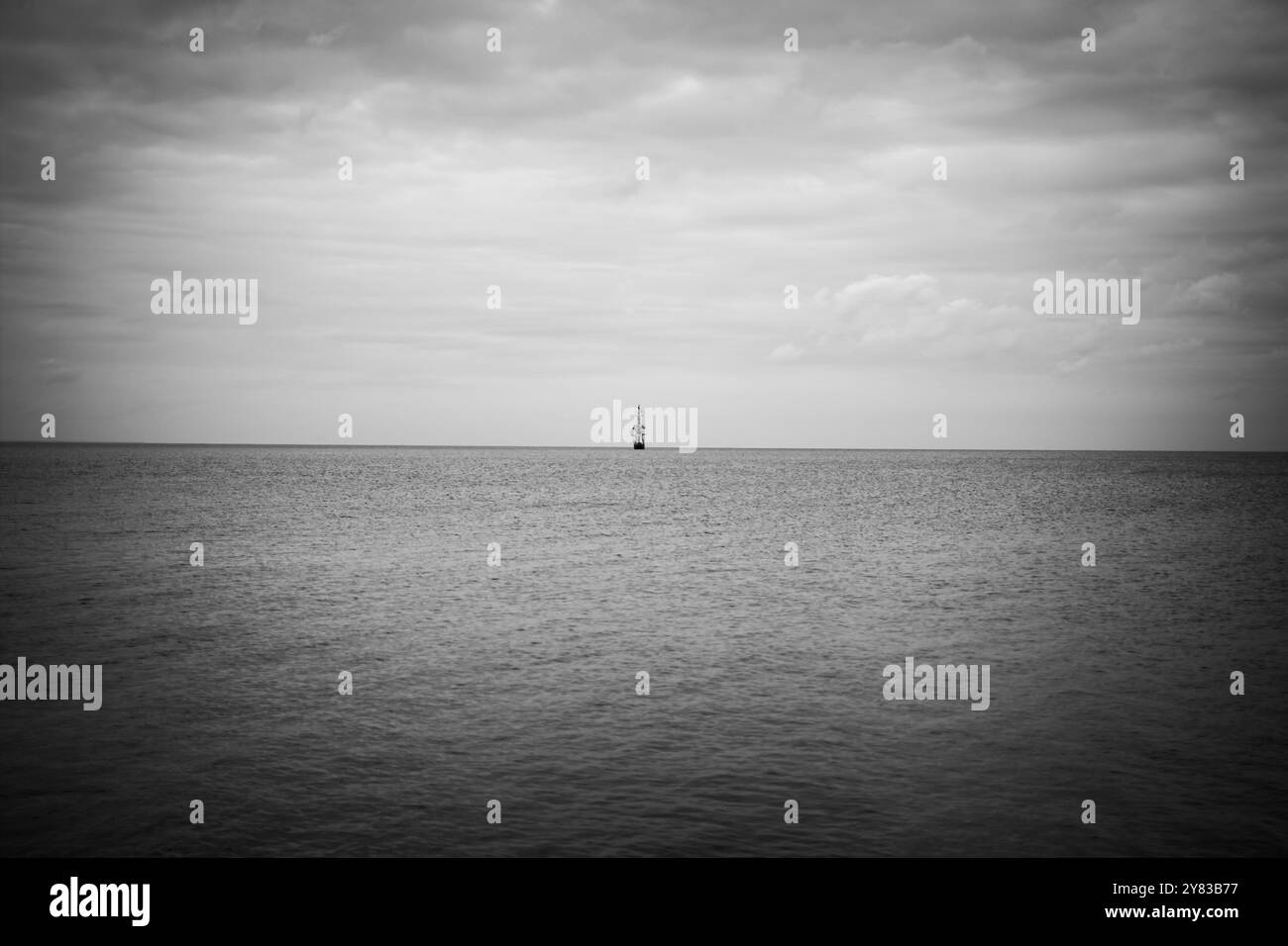 Old sailing ship at distant in silhouette against horizon over water at ...
