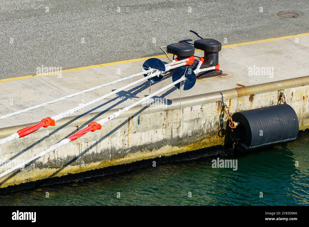 A tense stretched ship's thick mooring ropes at the mooring pole of the ...