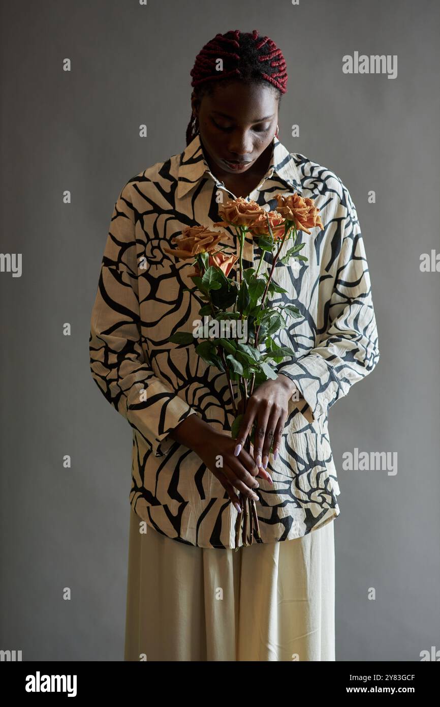 Delicate portrait of young Black woman posing with exotic blue flower ...