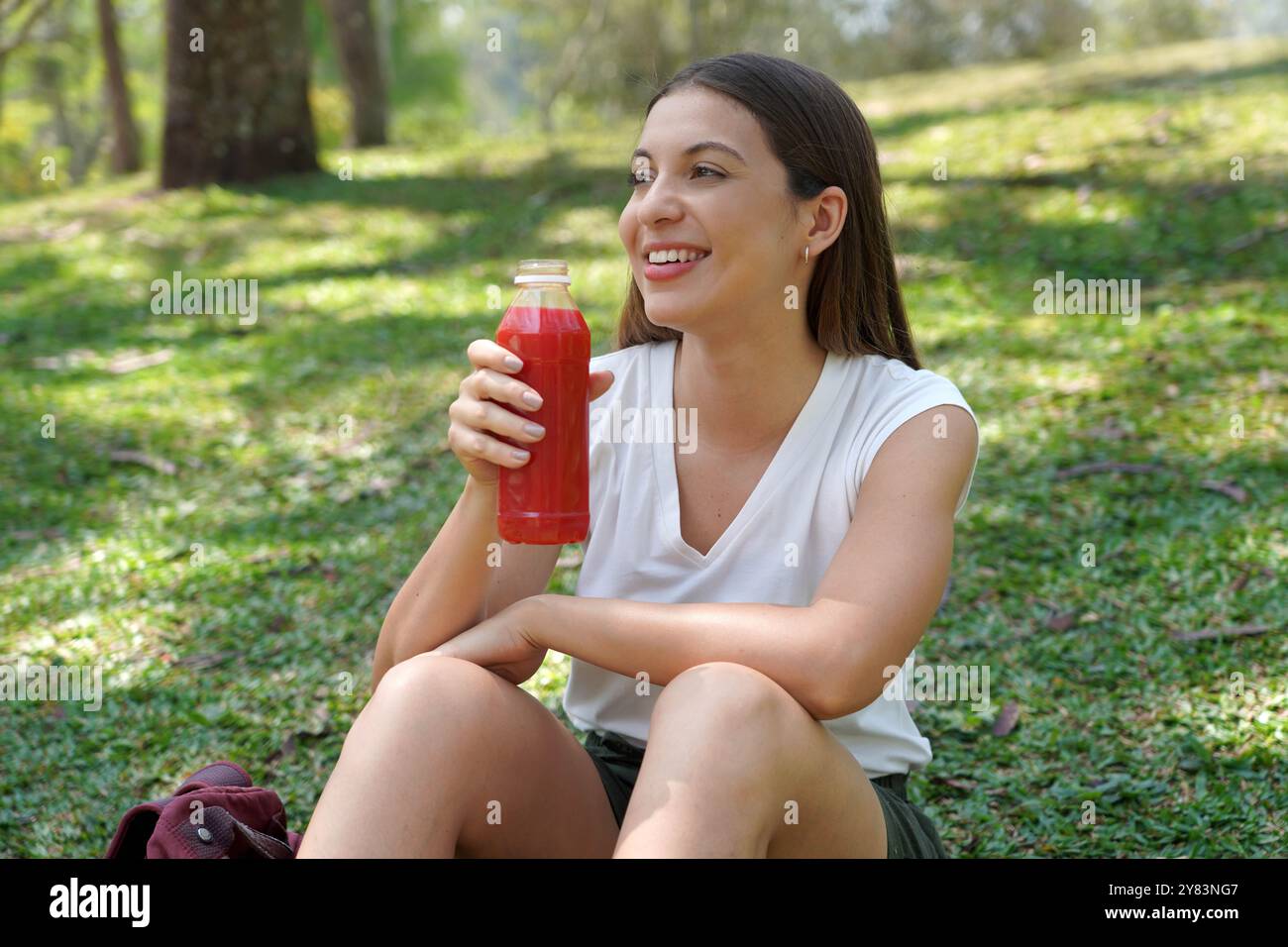 Young student girl sitting relaxed drinking red detox juice with ...