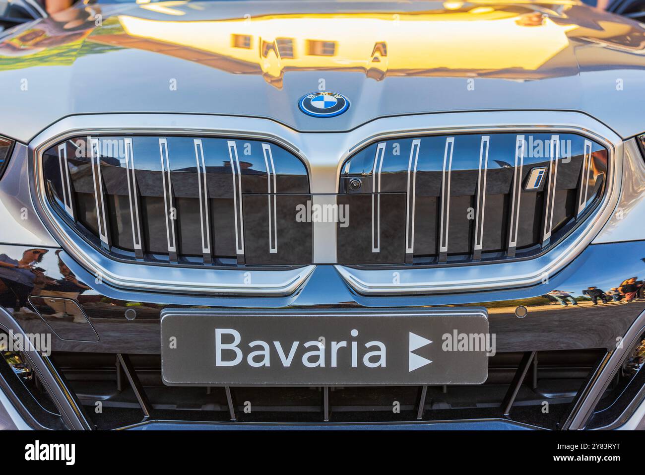 Close-up of BMW i4 electric car front grill with Bavaria logo, reflecting sunlight and ...