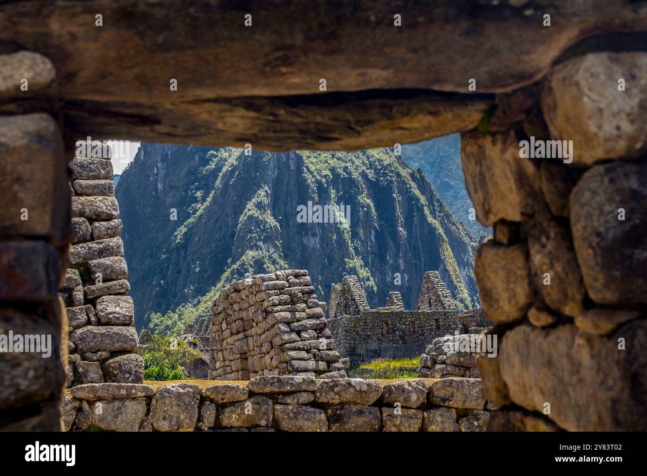View through a stone window of the archaeological site of the Inca city ...