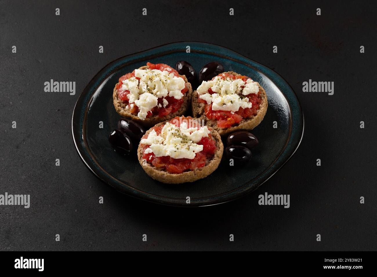 Cretan dakos consists of barley rusk topped with juicy tomatoes, feta ...
