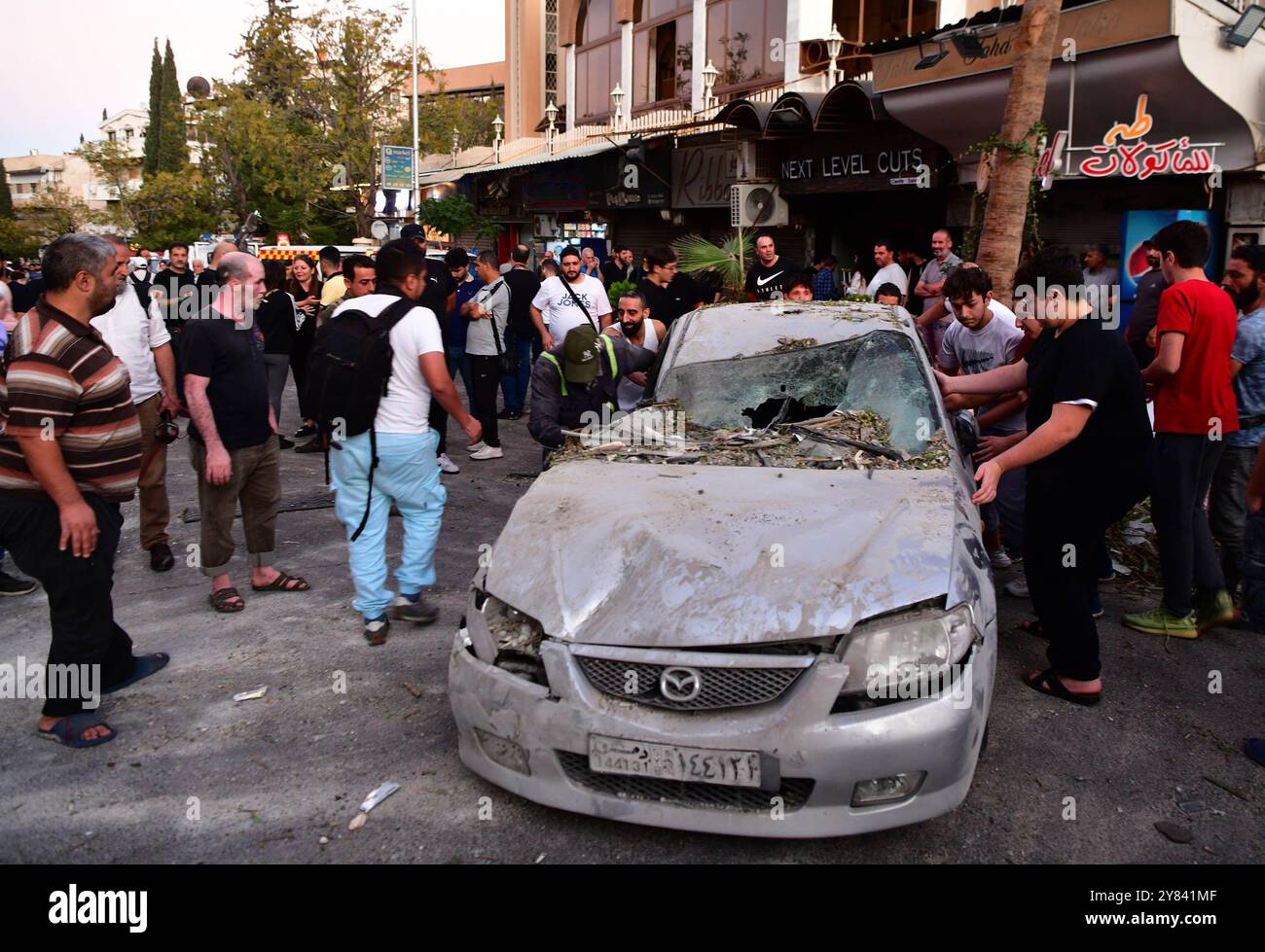 Damascus, Syria. 2nd Oct, 2024. People gather at the site after an ...