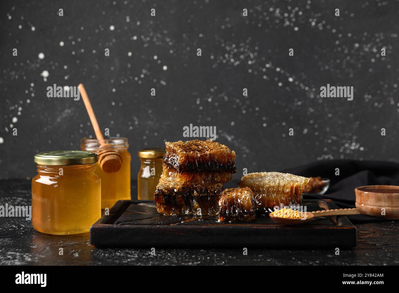 Sweet honey, combs and bee pollen on black background Stock Photo - Alamy