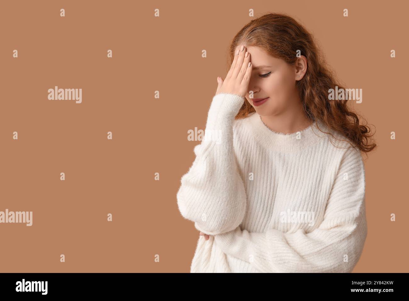 Portrait of ashamed young woman covering face on brown background Stock ...
