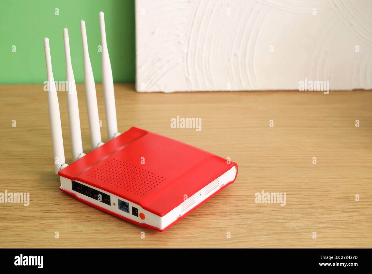 Modern wi-fi router on shelf near green wall, closeup Stock Photo - Alamy