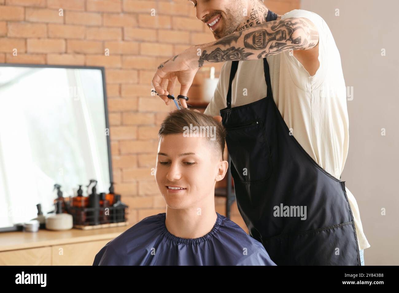 Male hairdresser giving haircut to client in barbershop Stock Photo - Alamy
