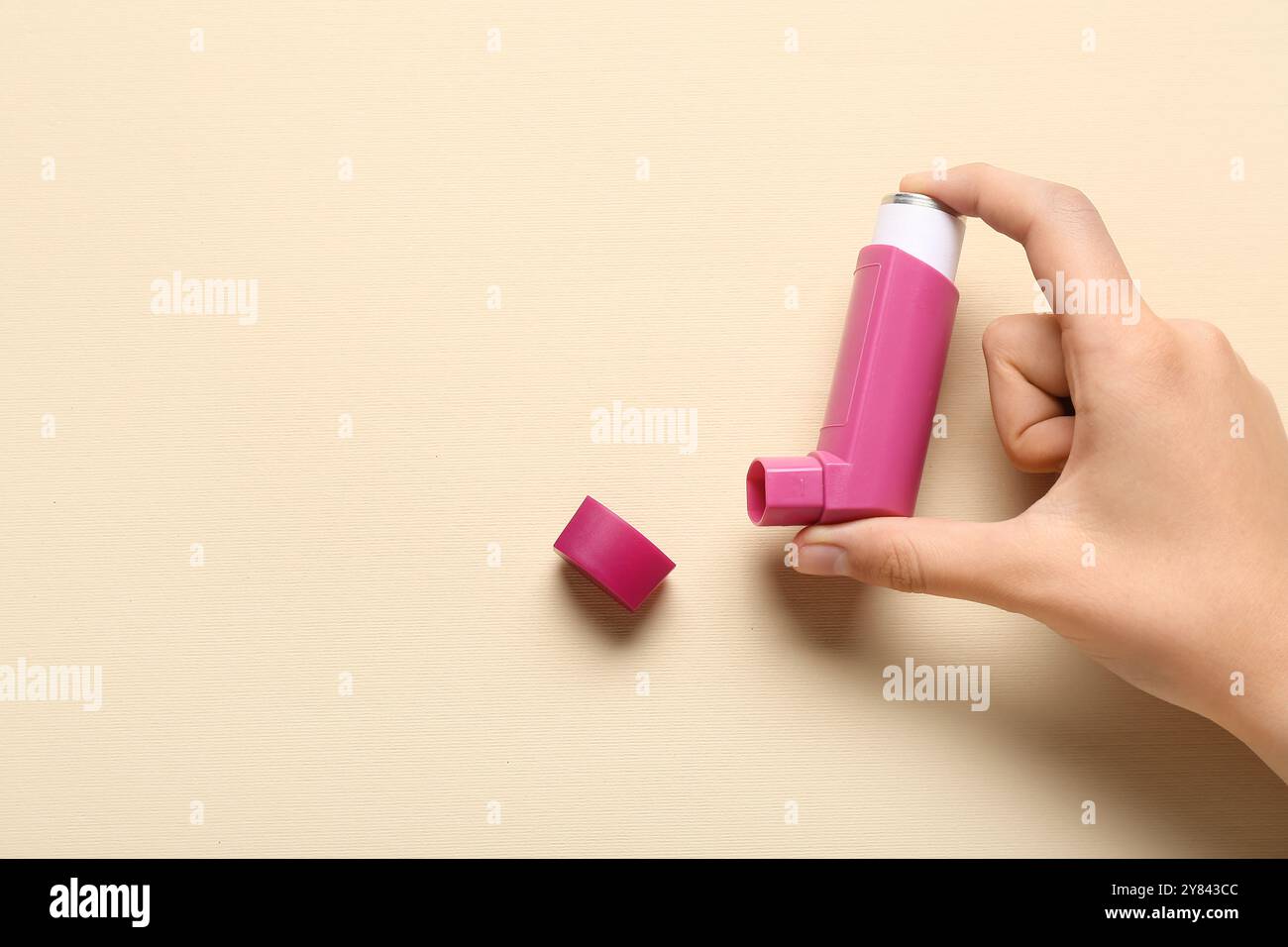 Child's hand with asthma inhaler on beige background Stock Photo - Alamy