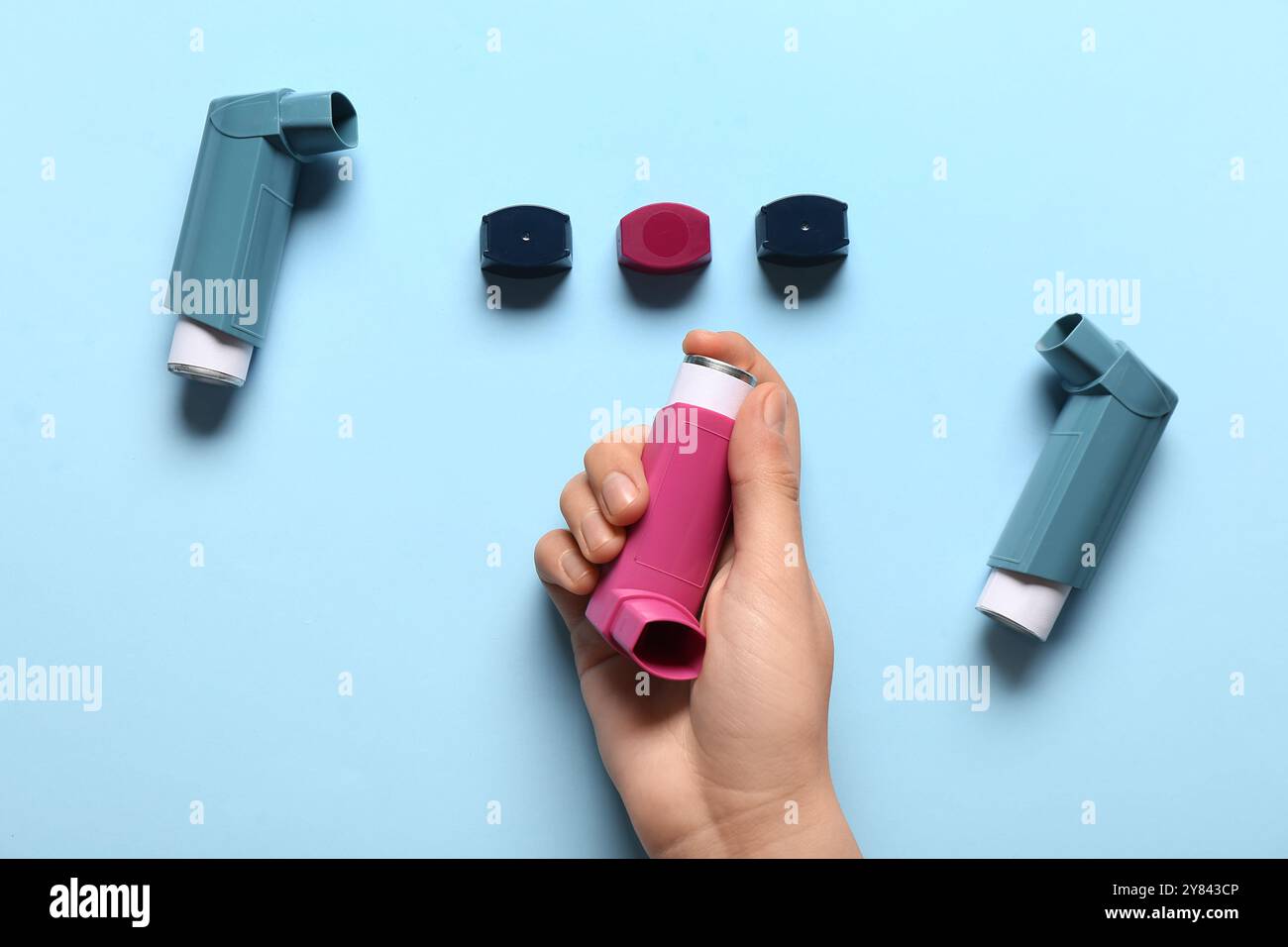 Child's hand with asthma inhalers on blue background Stock Photo - Alamy