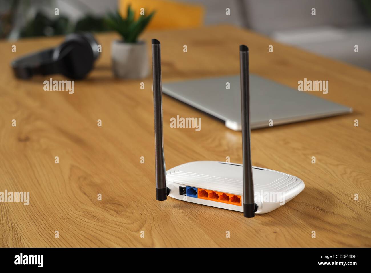 Modern wi-fi router on wooden table in room, back view Stock Photo - Alamy