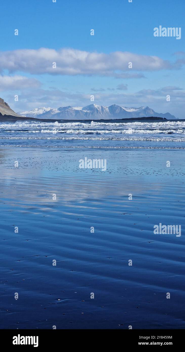 Arctic black sand beach and ocean waves meets the land on majestic ...