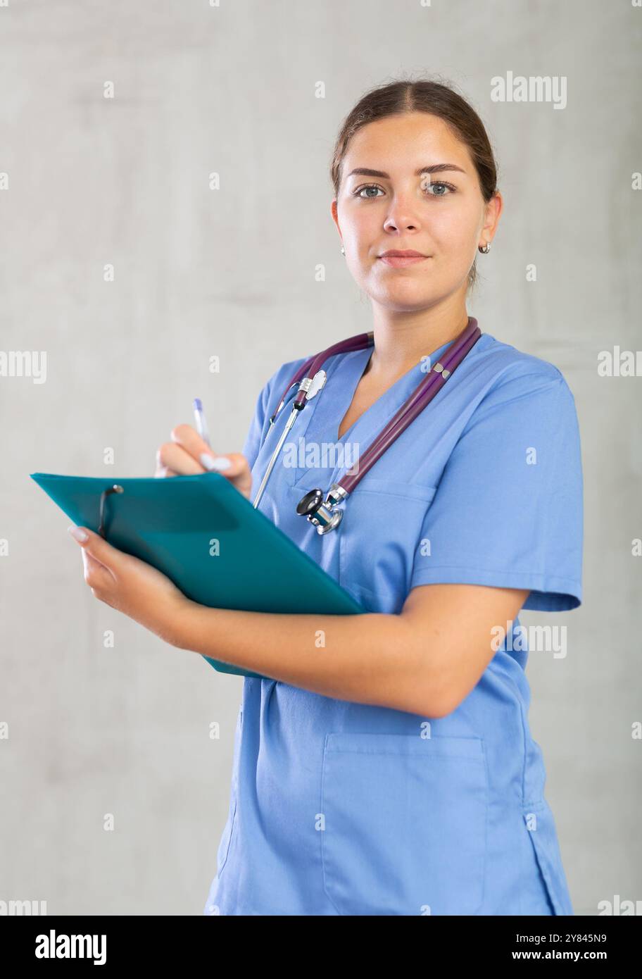 Positive nurse filling out medical history forms in documents Stock ...