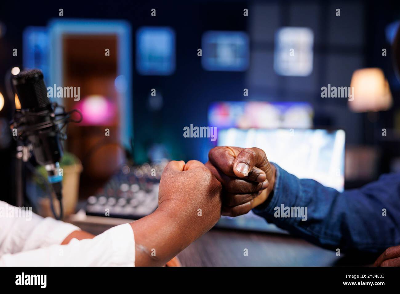 Closeup of host welcoming guest to home studio and preparing to hear ...