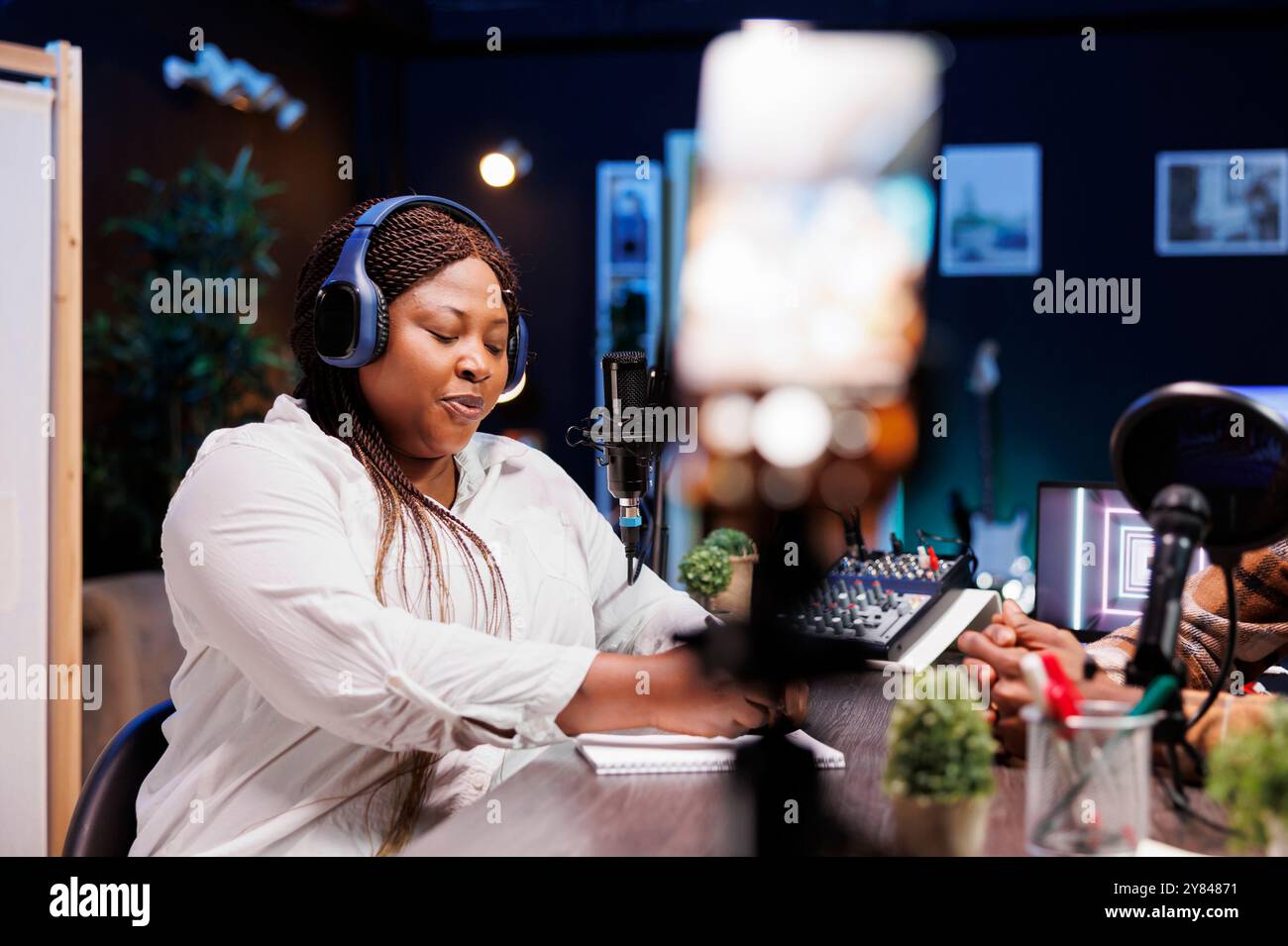 Journalist records interview with cellphone on tripod in studio ...