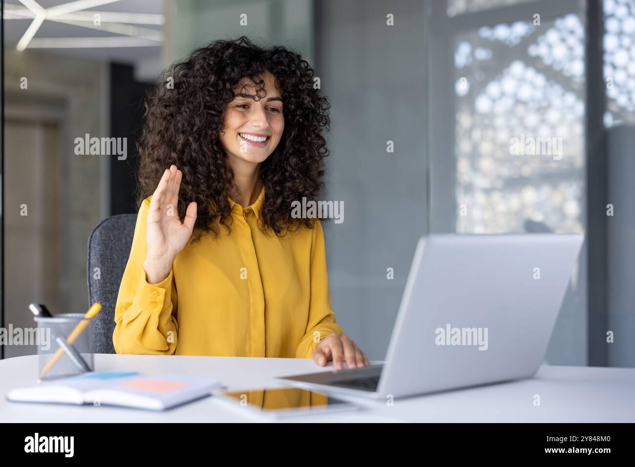 Hispanic businesswoman participating in virtual meeting using laptop in ...