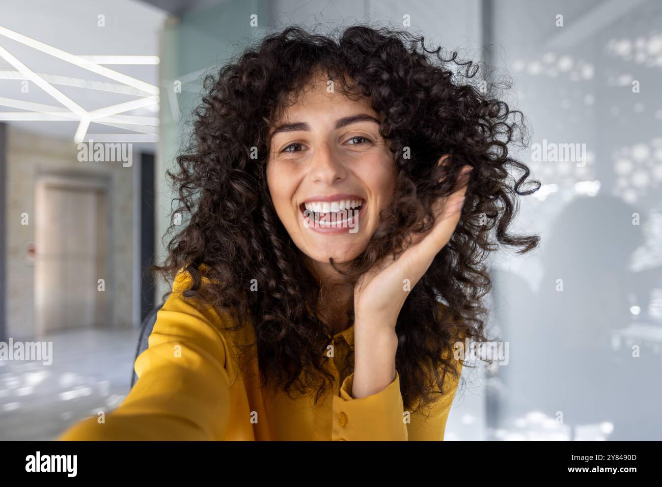 Joyful woman happily smiles during phone video call in office ...