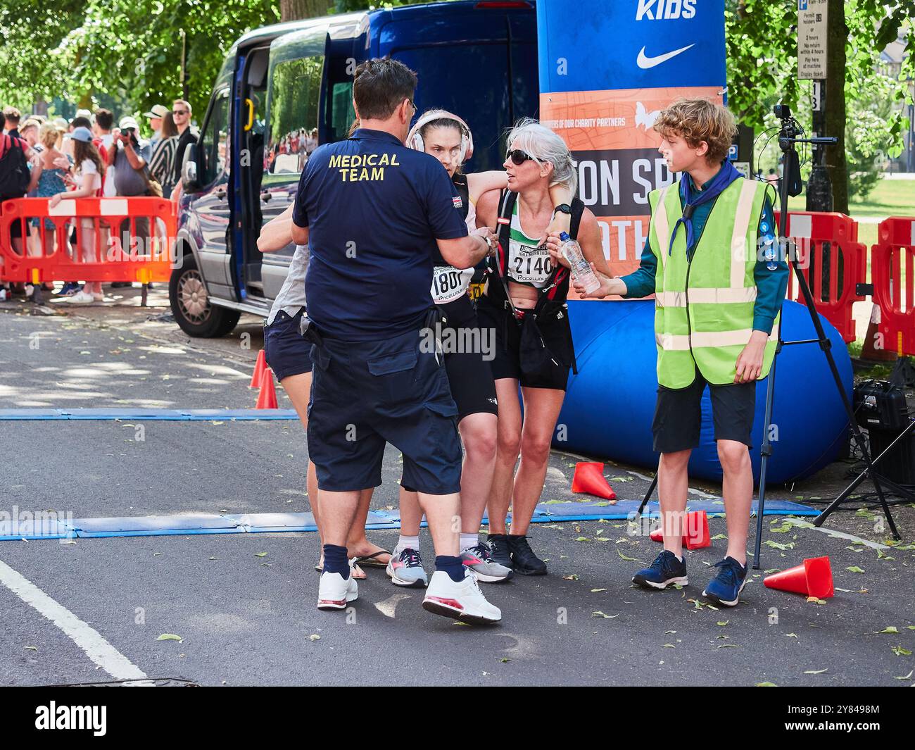 Exhausted half-marathon runner receiving first aid treatment at the ...