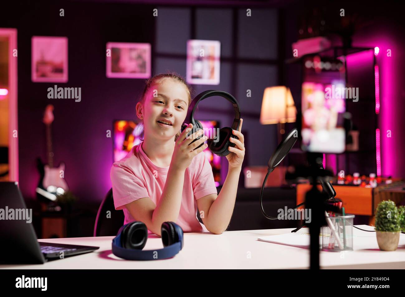 Young tech niche influencer filming headphones review, comparing ...