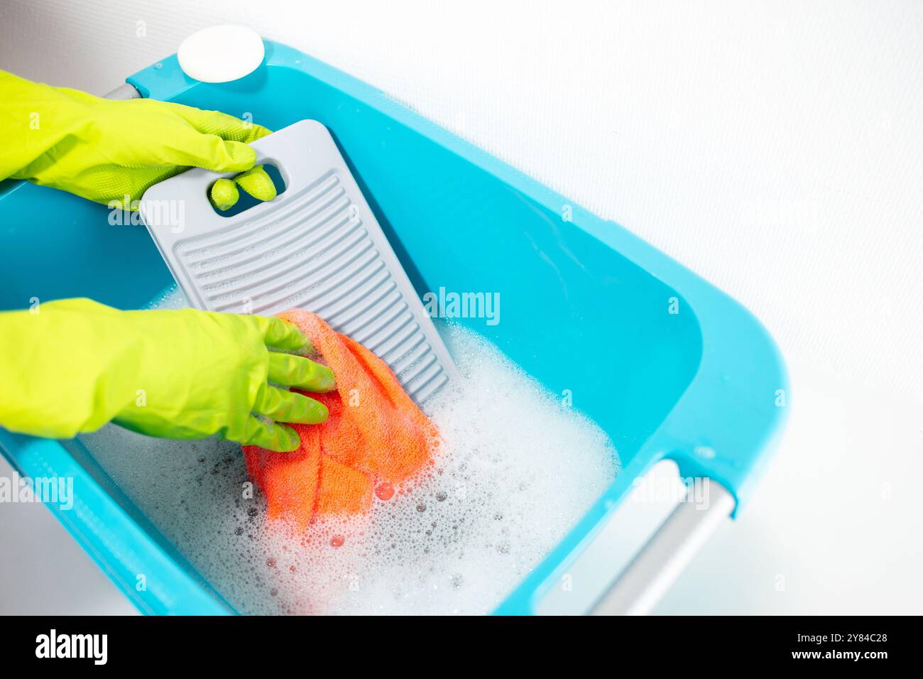 Hand washing linen, removing dirt and stains, yellow rubber gloves ...
