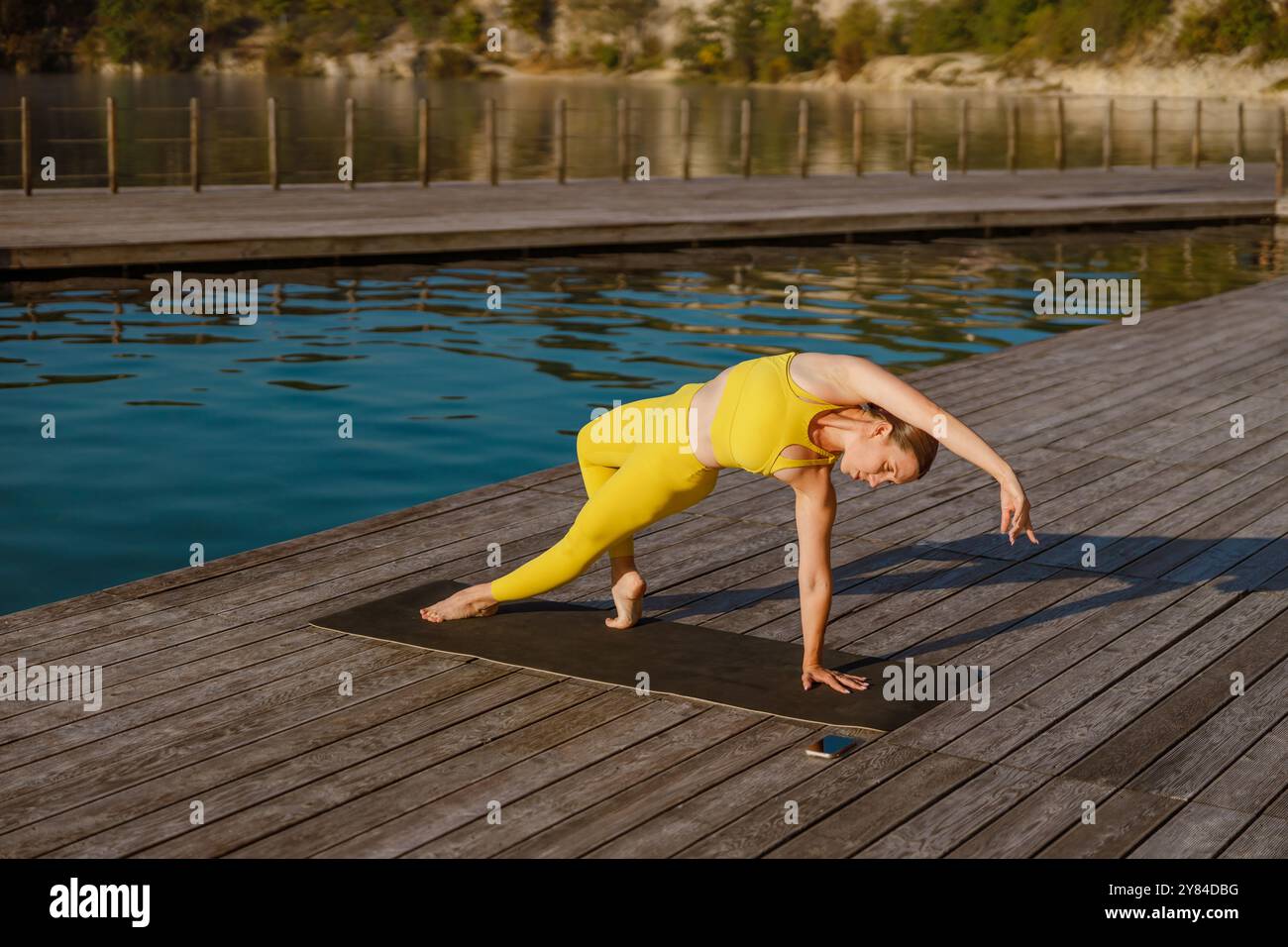 A serene outdoor yoga posture being practiced in vibrant yellow attire ...