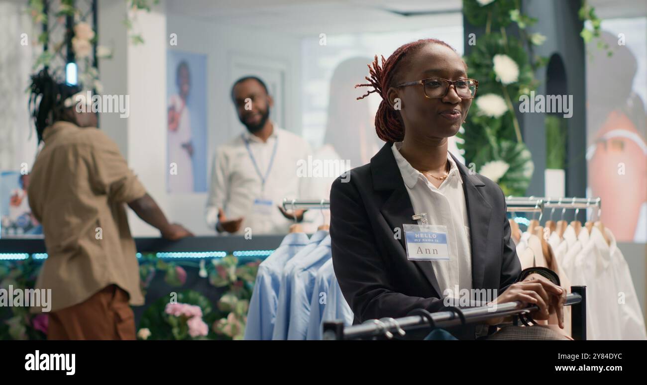 Employee restocking luxurious clothing store with elegant assortment of ...
